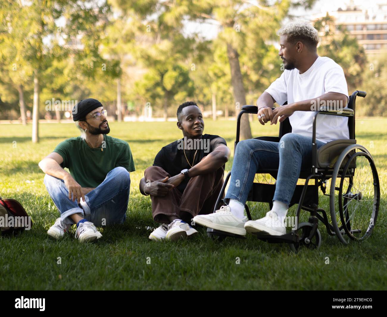 Group of diverse male friends one of them in a wheelchair talking to ...