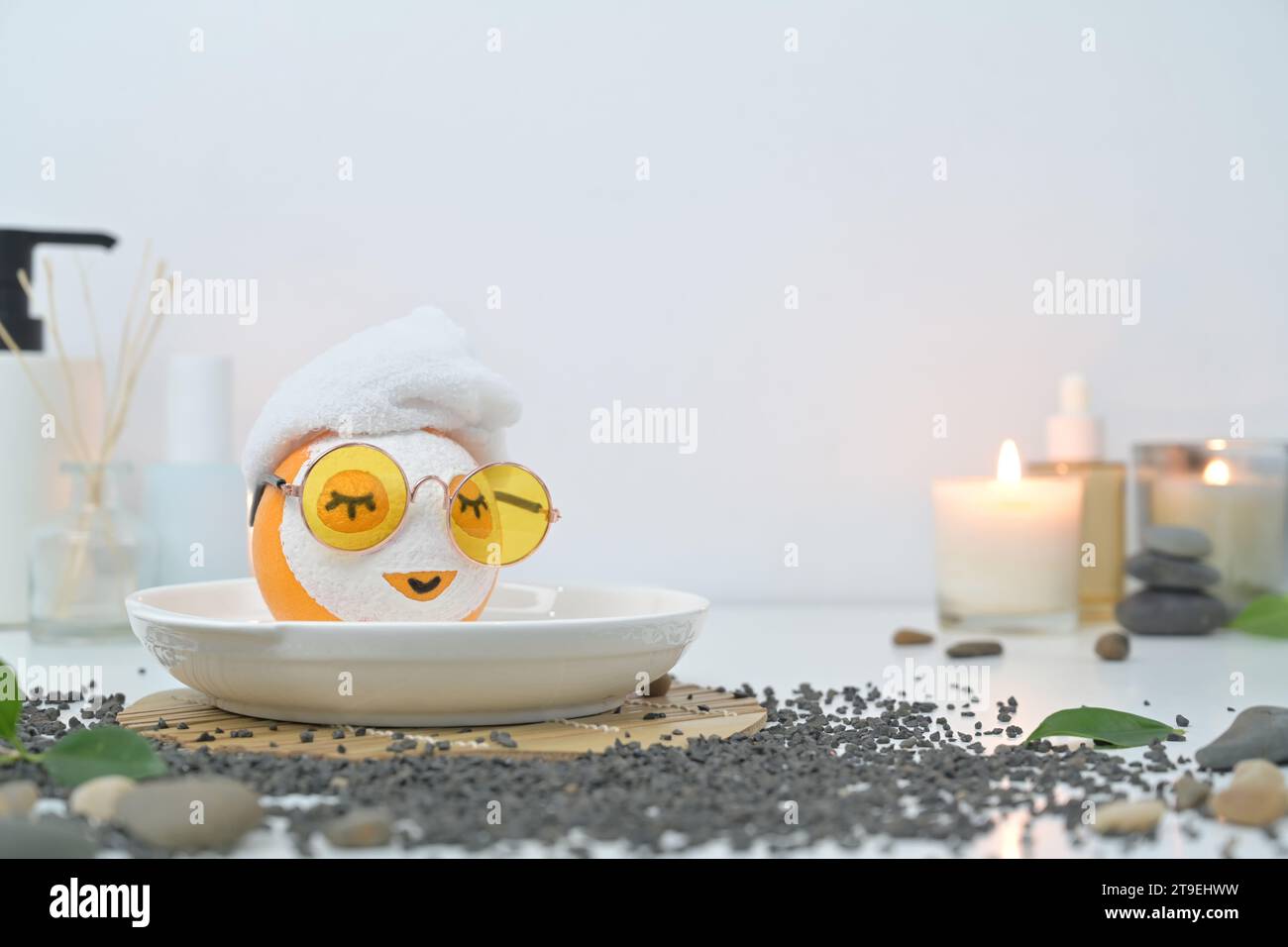 Relaxed orange fruit with mask and towel looking like in bath or Onsen ...