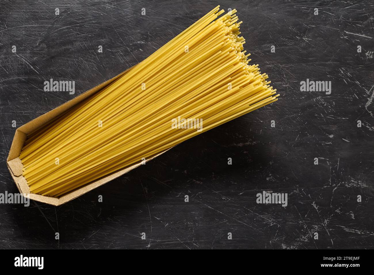Spaghetti raw, long pasta in cardboard box, top view dark background ...