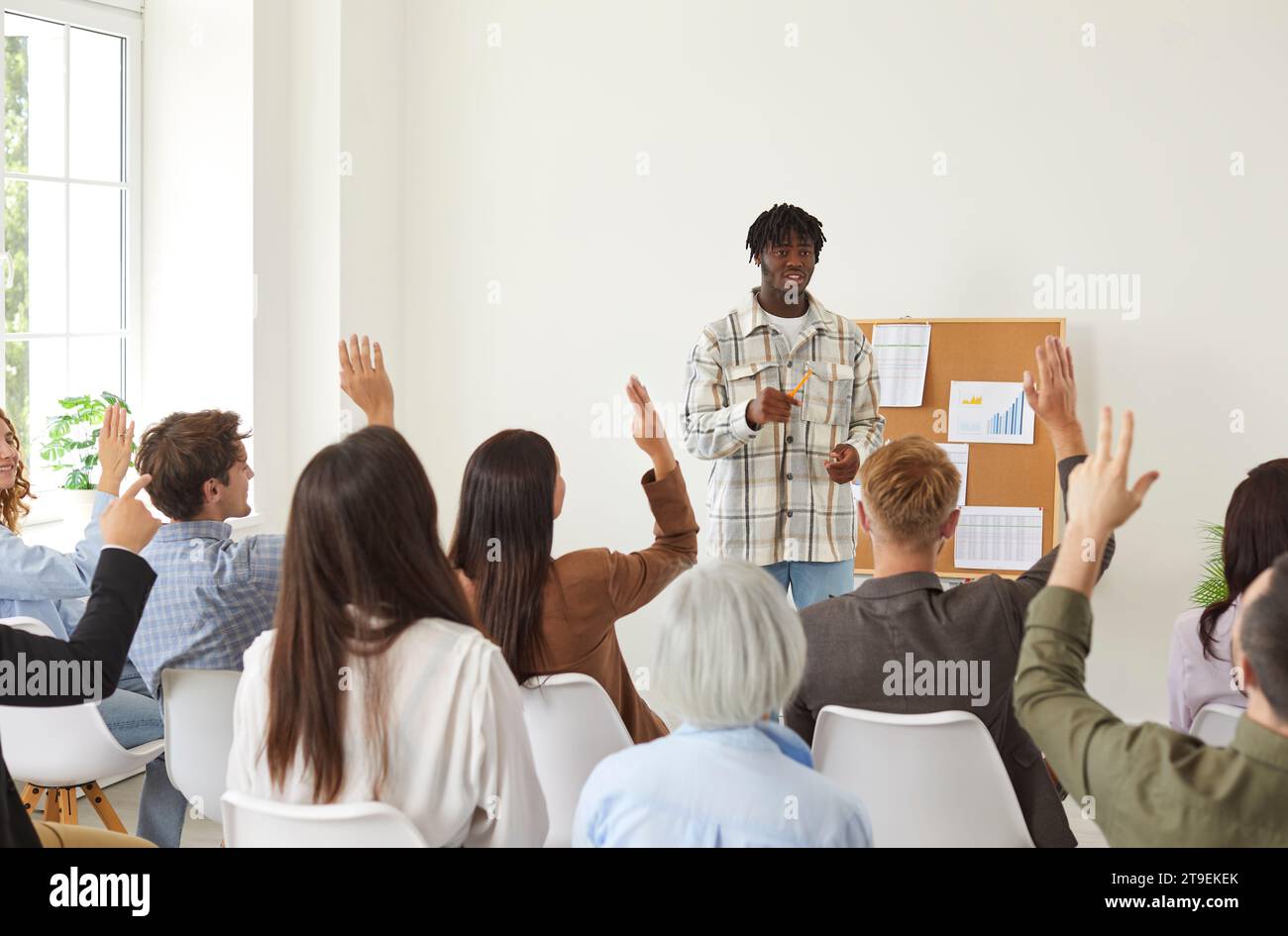 Group of diverse people raise their hands to ask question or vote ...