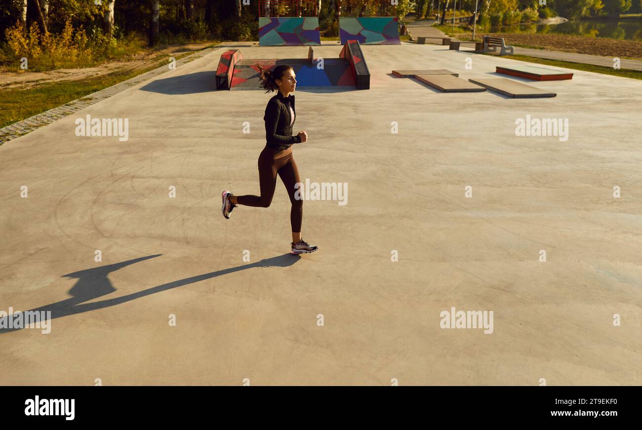 Top view of sporty woman running in a city park. Girl in sportswear ...