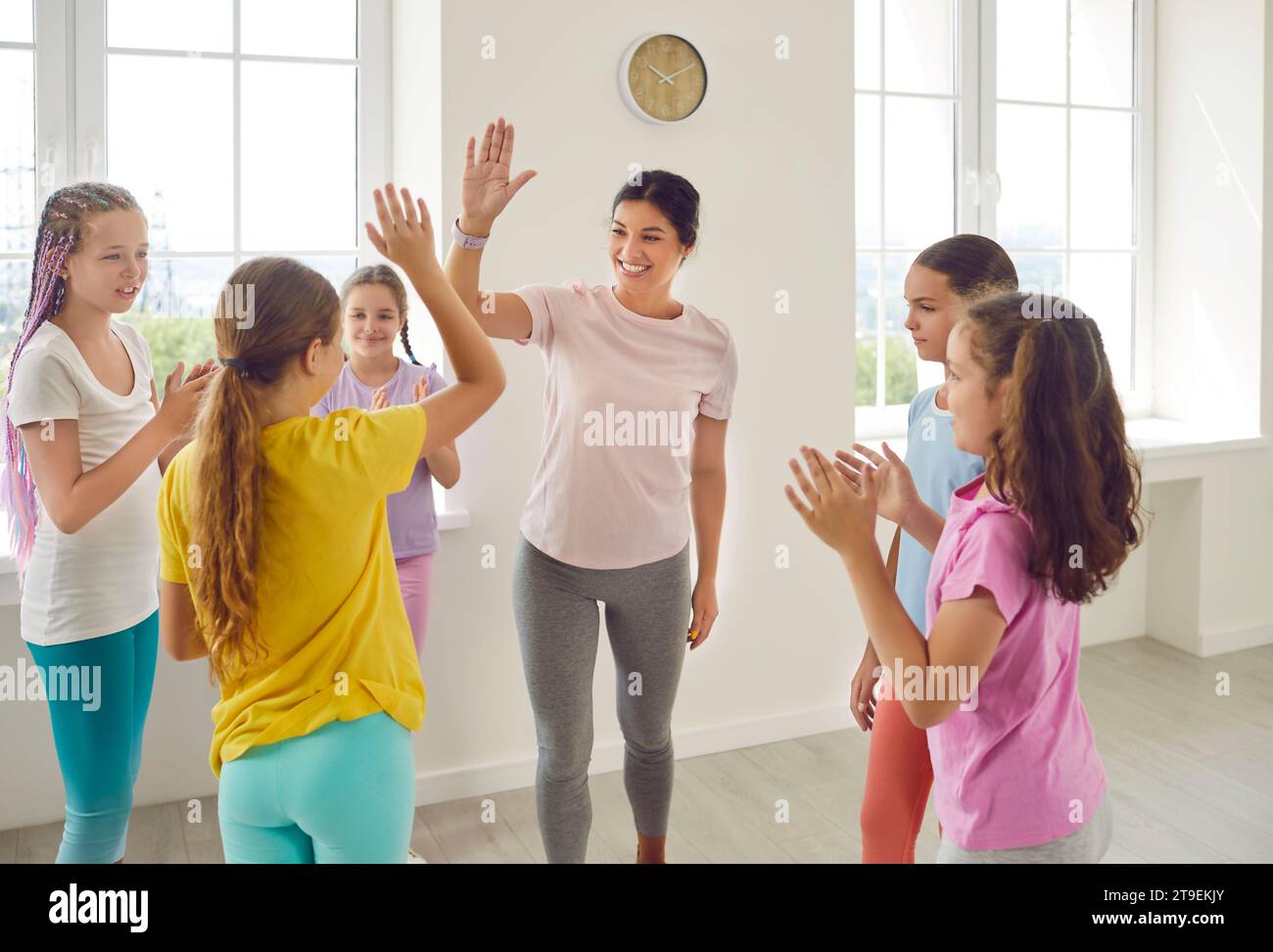 Happy dance sport trainer giving high five to her kids at the end of ...