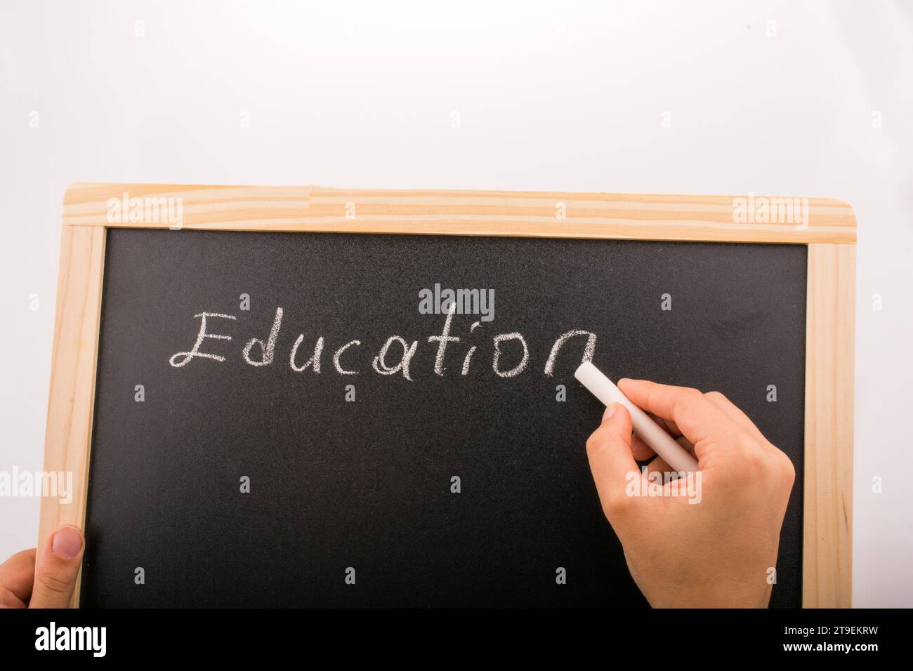 Hand holding a blackboard with 'education' written on it on a white ...