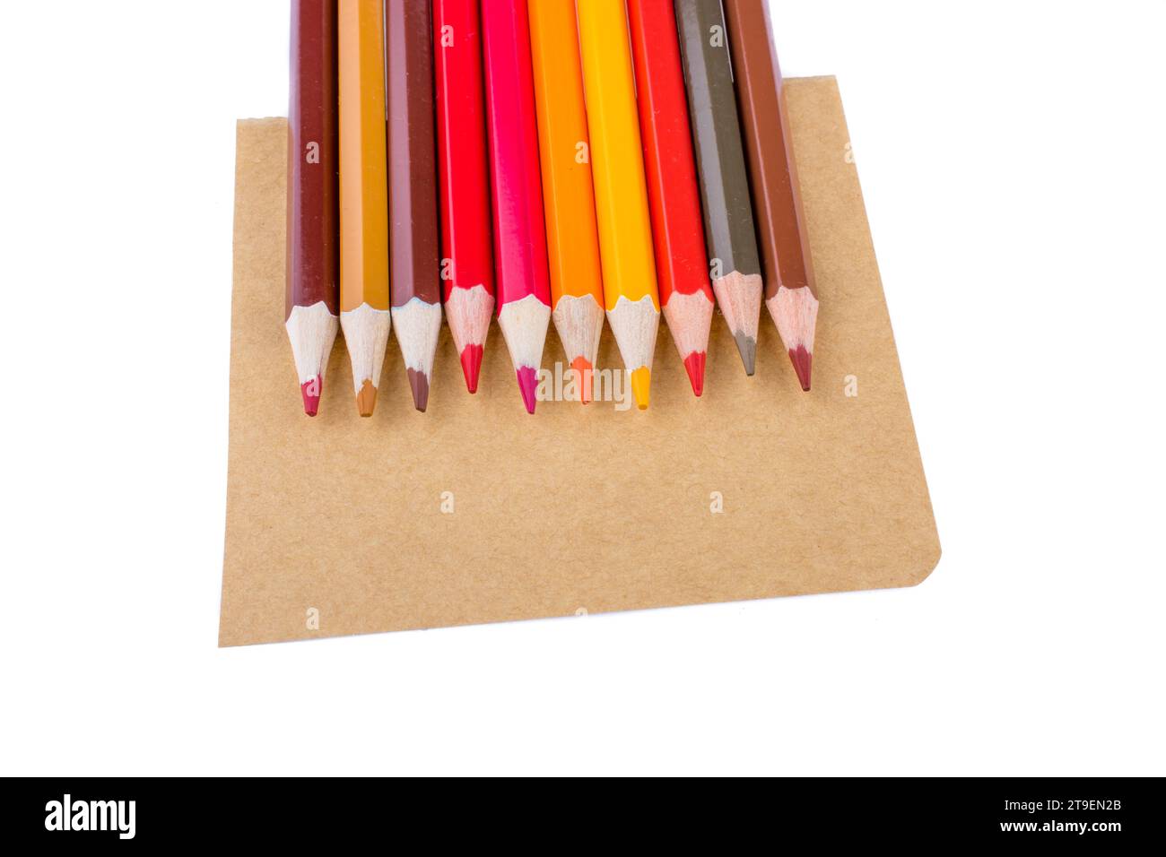 Color pencils placed on brown sheet of paper Stock Photo - Alamy