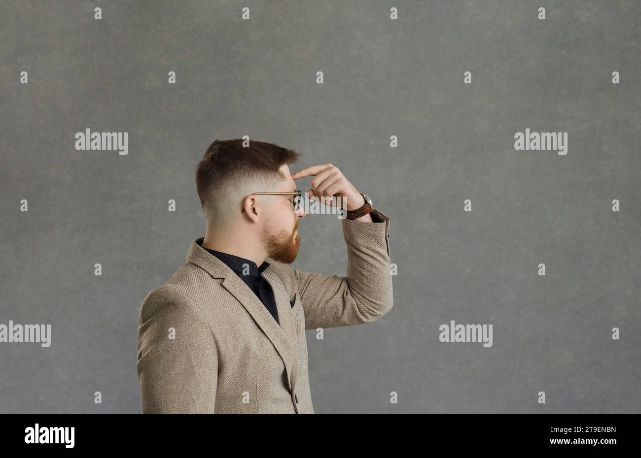 Portrait of business man thinking putting finger on forehead in ...