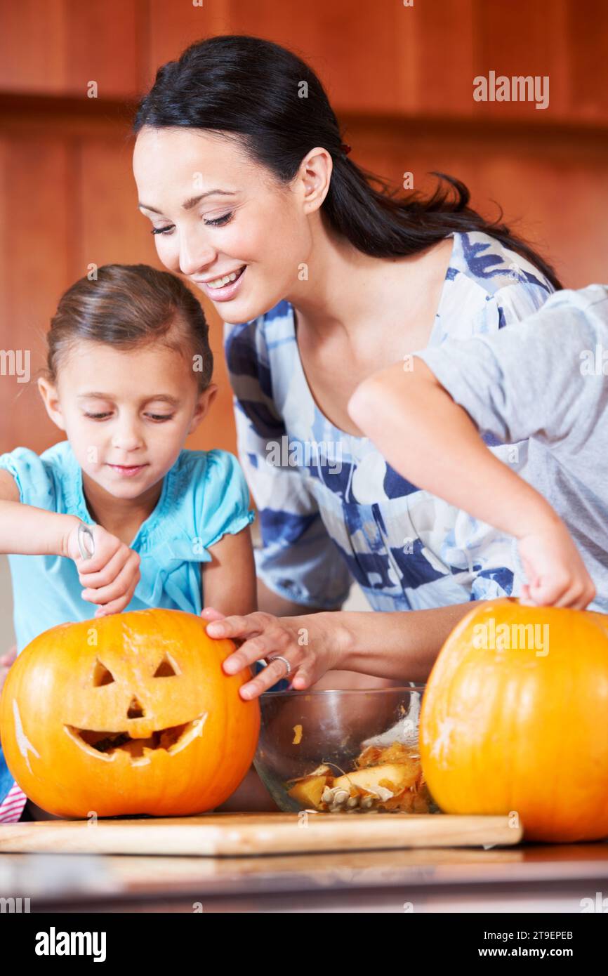 Halloween, pumpkin and mother with child in the kitchen for holiday celebration at home ...