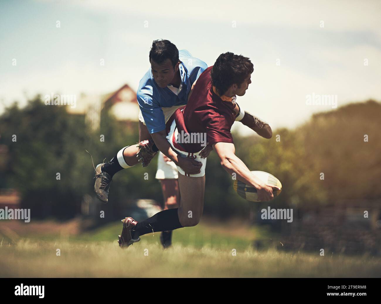 Rugby, tackle and fitness men on a field for sports, ball or action ...