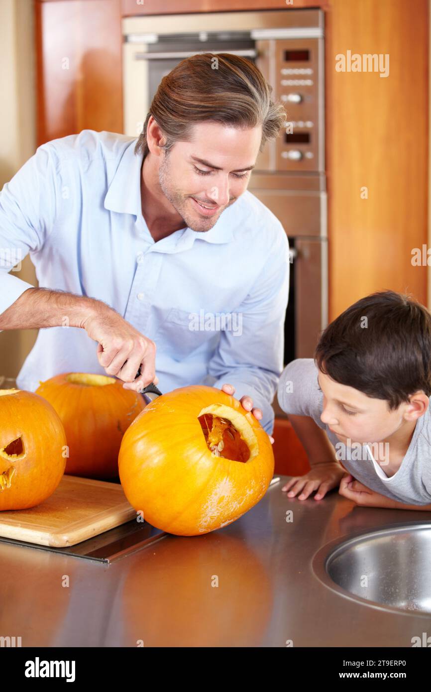 Halloween, pumpkin and father with kid in a kitchen for carving ...