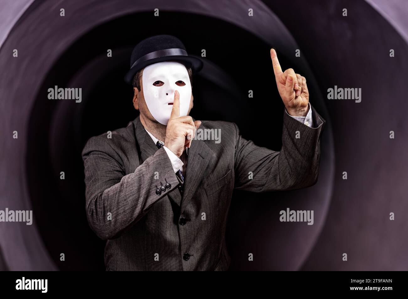 A man in a mask shows a gesture for silence before the enter of the ...