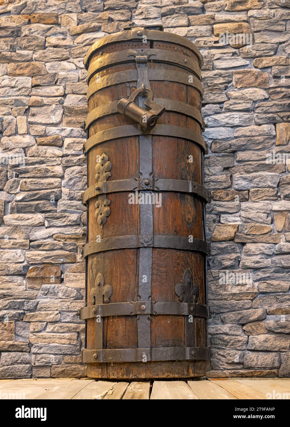 Historic vertical chest with fittings against a stone wall on a plank ...