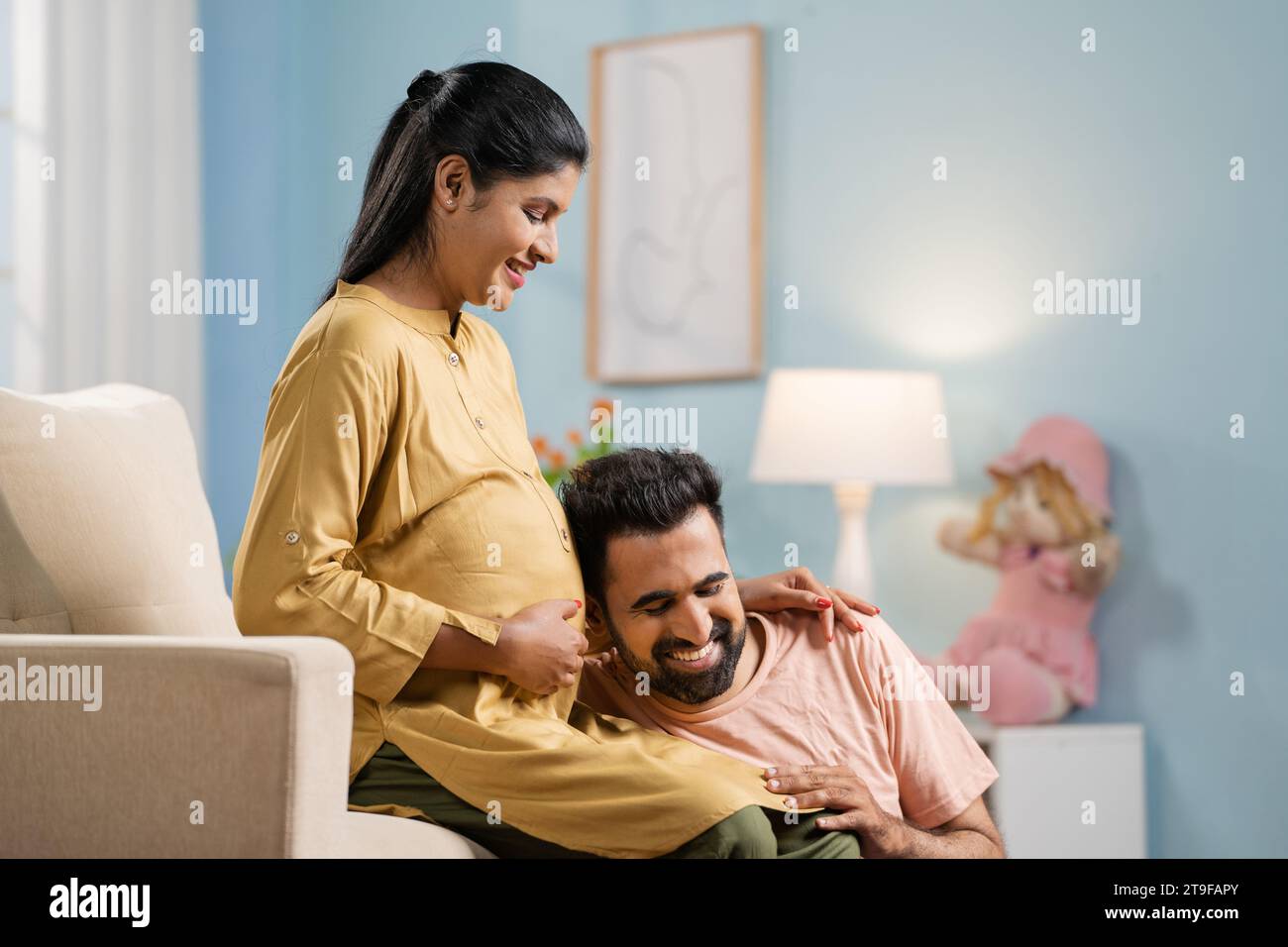 Happy indian husband listening baby sound of pregnant wifes belly at ...