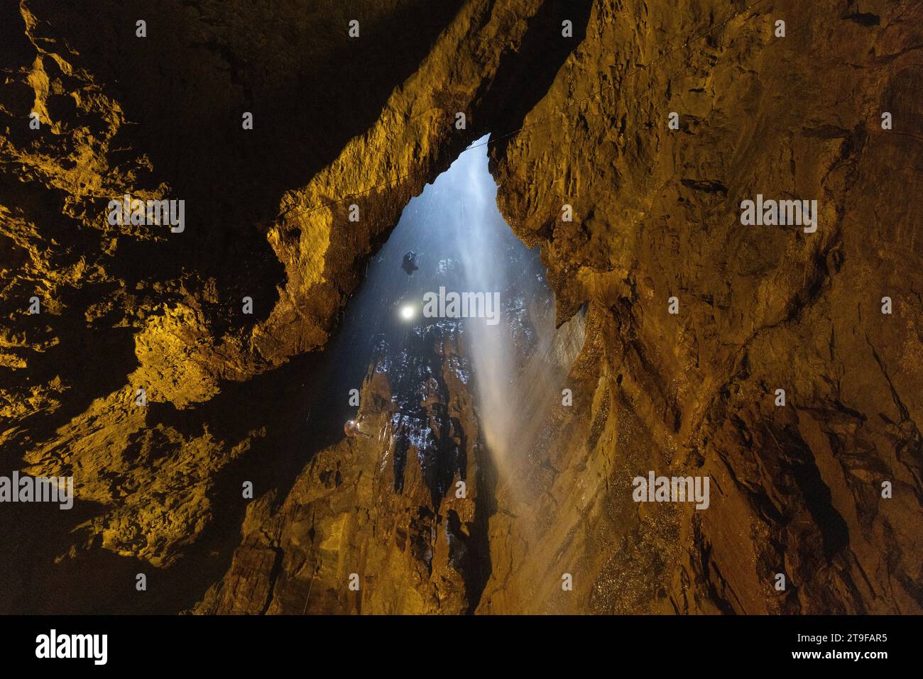 Caver descending into Gaping Gill cave during an open day winch event ...