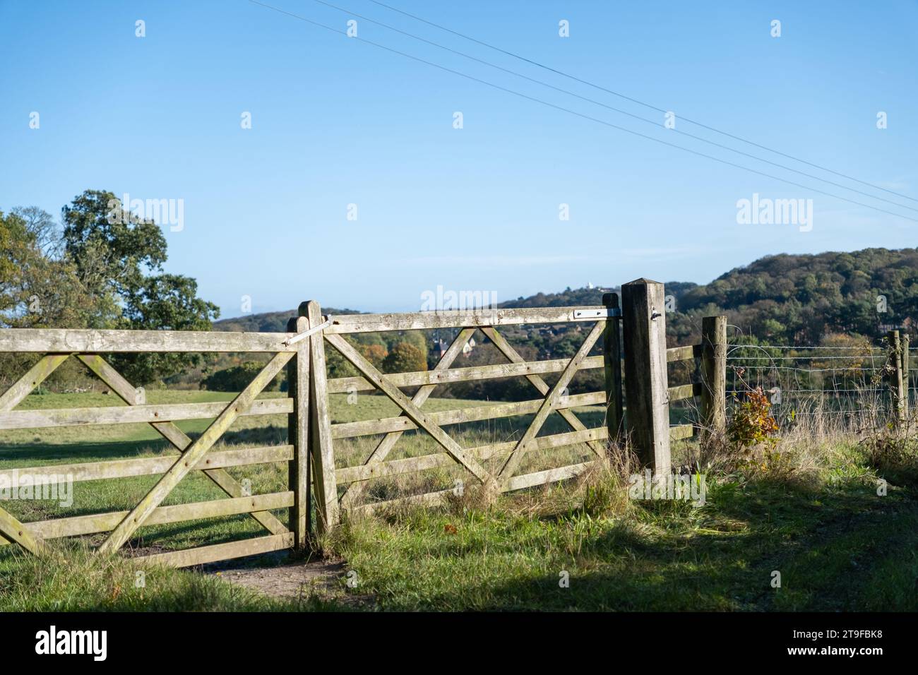 Wooden gate across a grassy meadow in the countryside. Captured on a ...