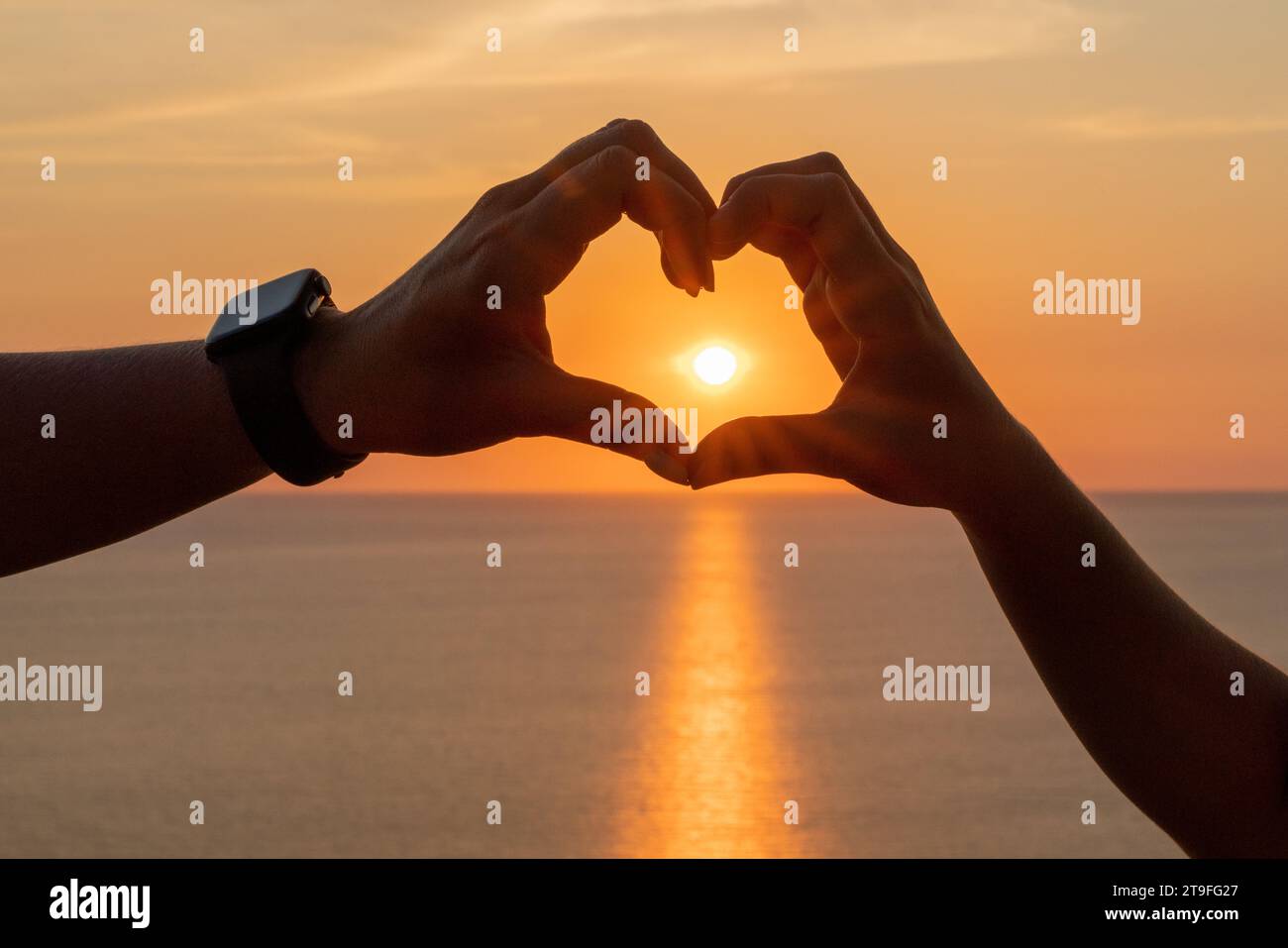 Hands heart sea sanset. The image features a beautiful sunset with two ...