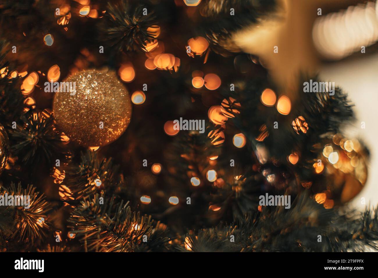Golden Christmas ball hanging on a Christmas tree with golden garland ...