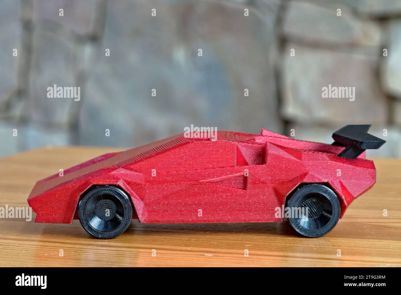 Plastic toy model car made on 3d printer isolated on blurred background ...