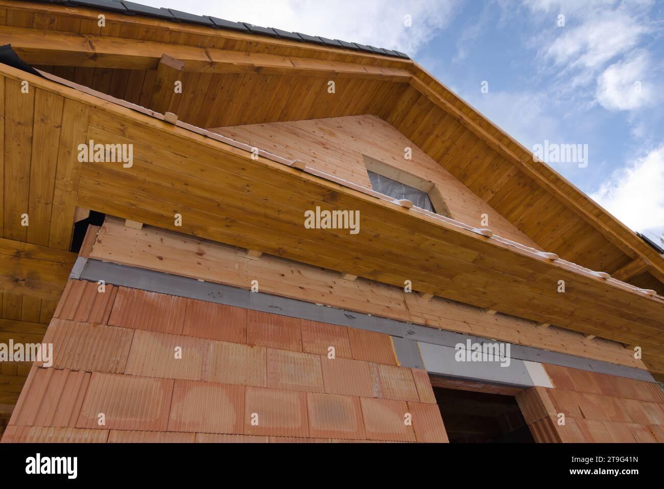 Construction of unfinished house made of bricks, wood and timber ...
