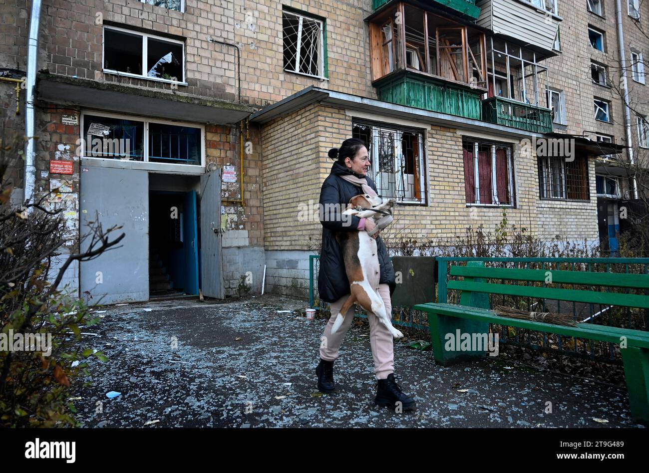 Kyiv, Ukraine. 25th Nov, 2023. A woman takes her dog from a partially ...