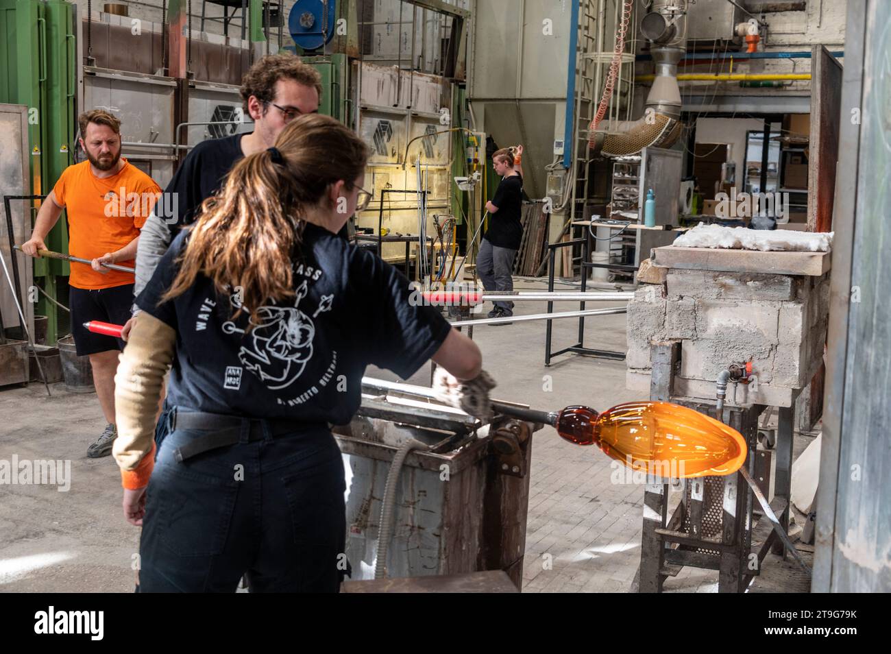 With the help of an apprentice, aglassblower using a 2m long ion rod ...