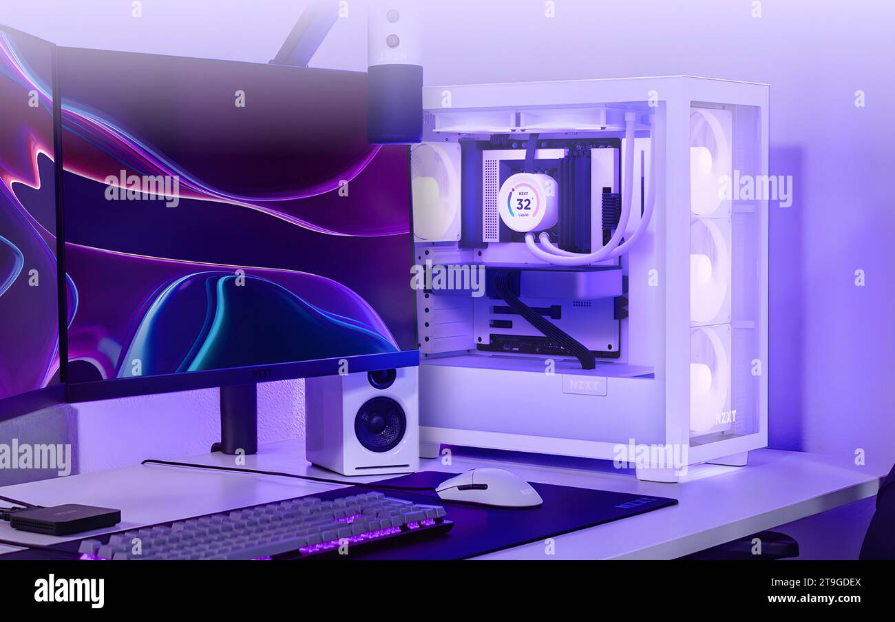 A desktop computer setup featuring a purple backdrop, keyboard, and ...