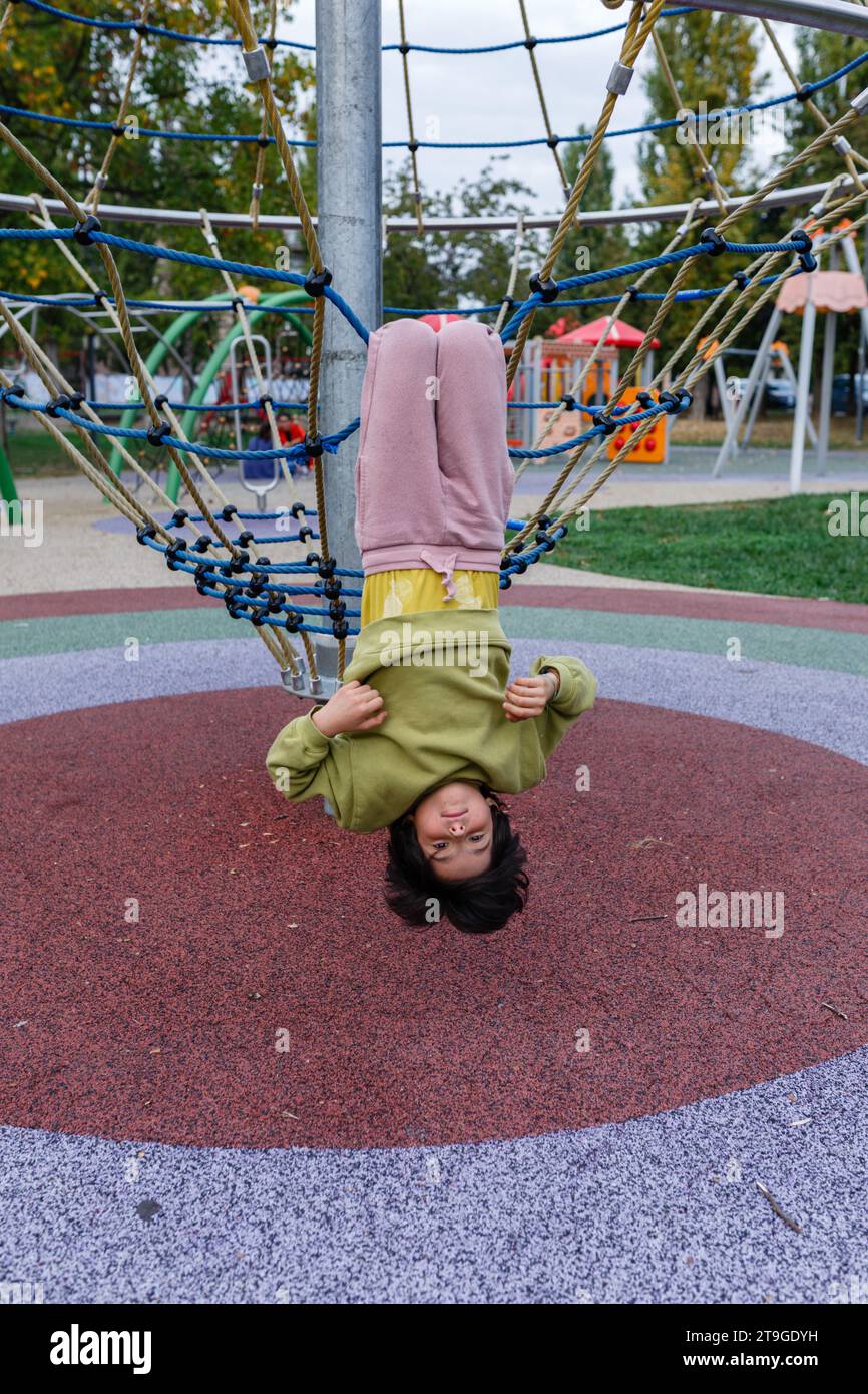 girl hanging upside down on the playground Stock Photo - Alamy