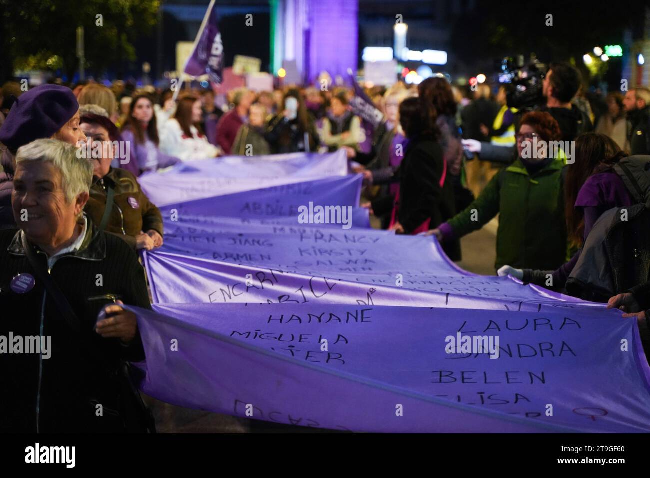 Dozens of women carry placards during a march against violence against ...