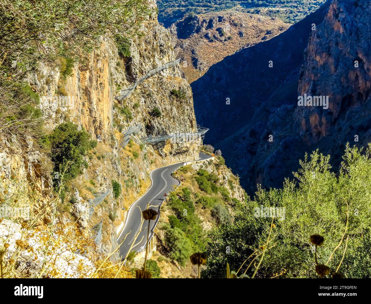 A view over the road that meanders through the Topolia Gorge, Crete on ...