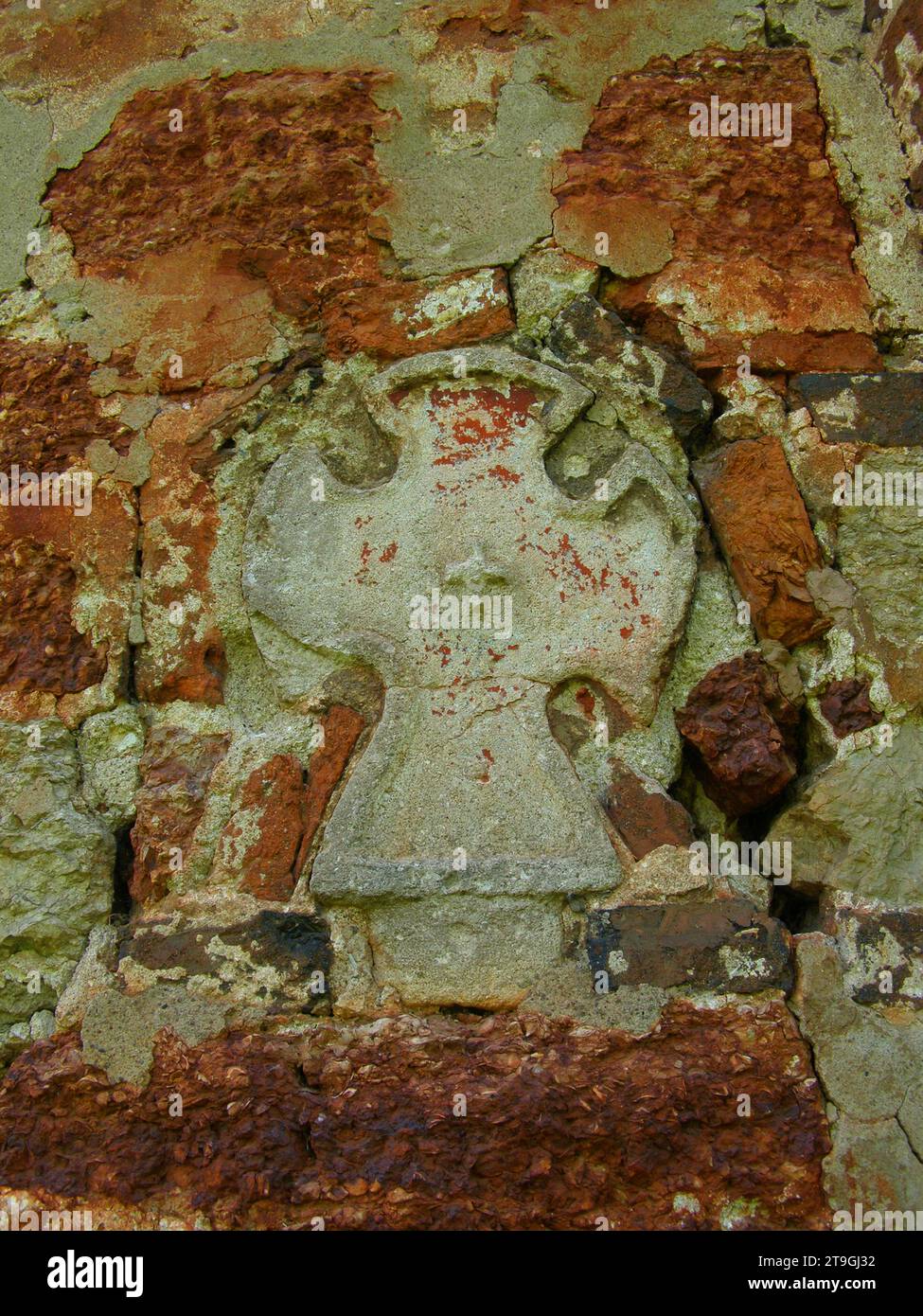 An archaic ancient cross from a burnt temple is built into the wall of ...