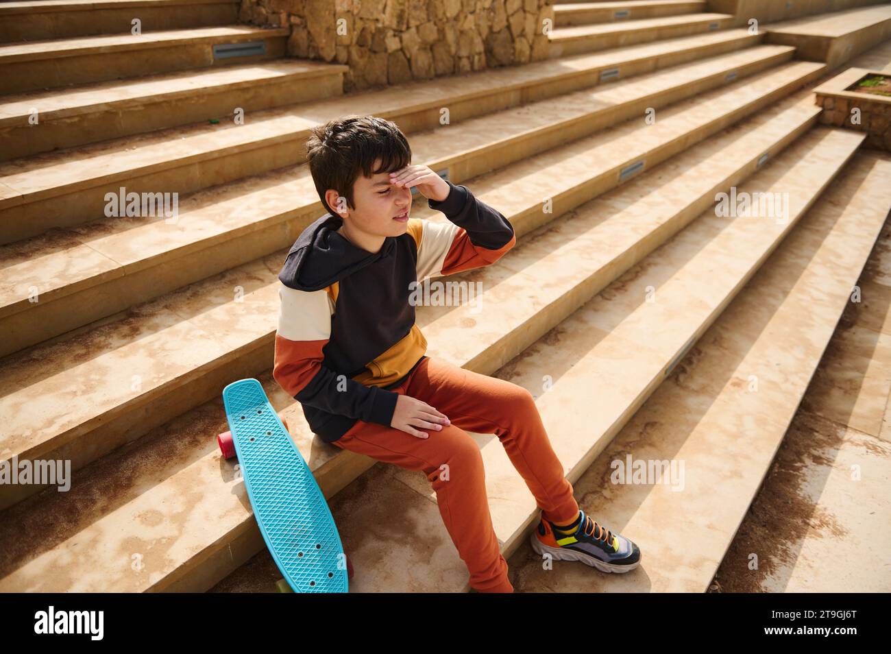 Portrait of a teenage student boy, schoolboy in sportswear sitting on ...