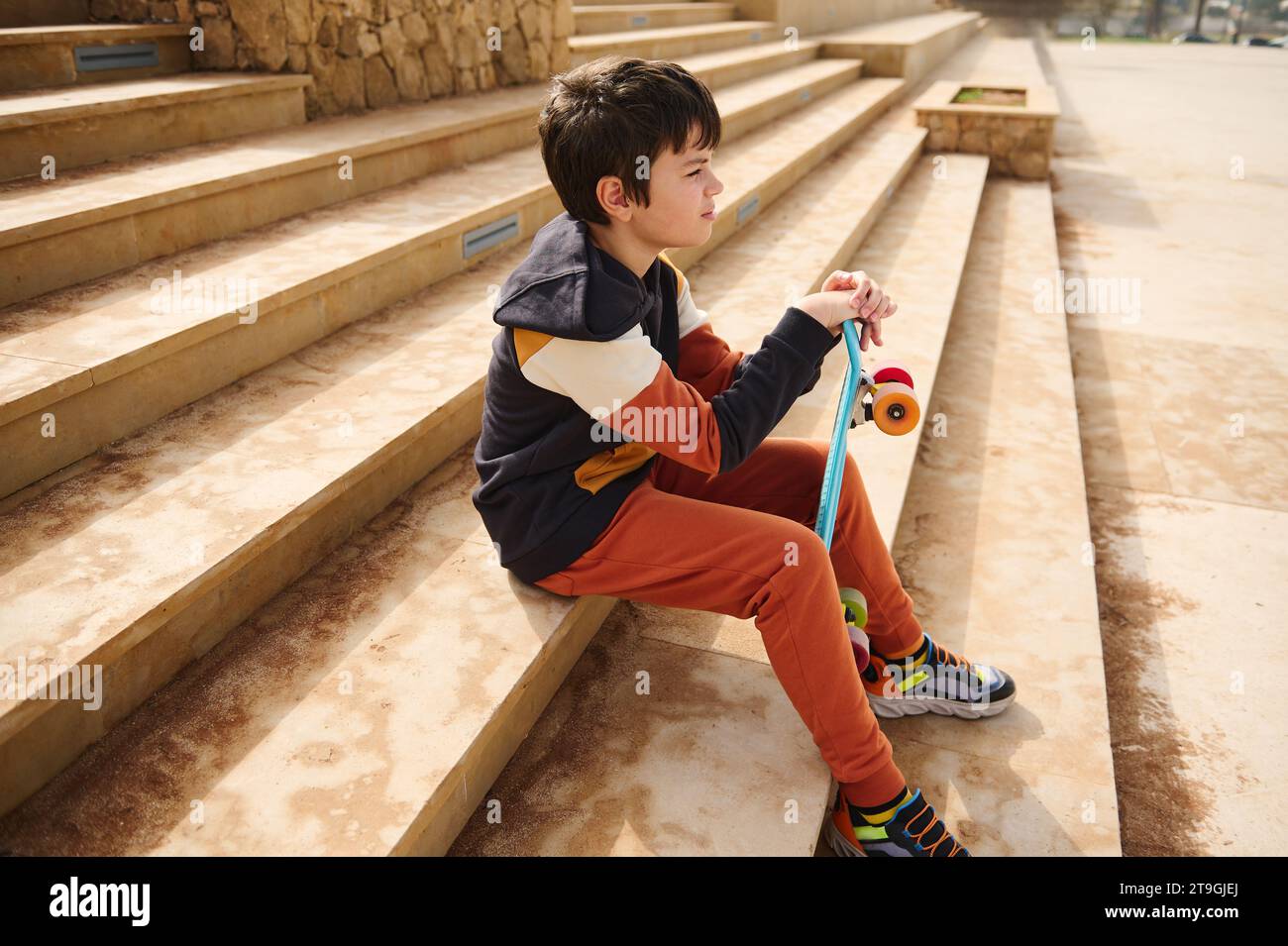 Portrait of a teenage student boy, schoolboy in sportswear sitting on ...