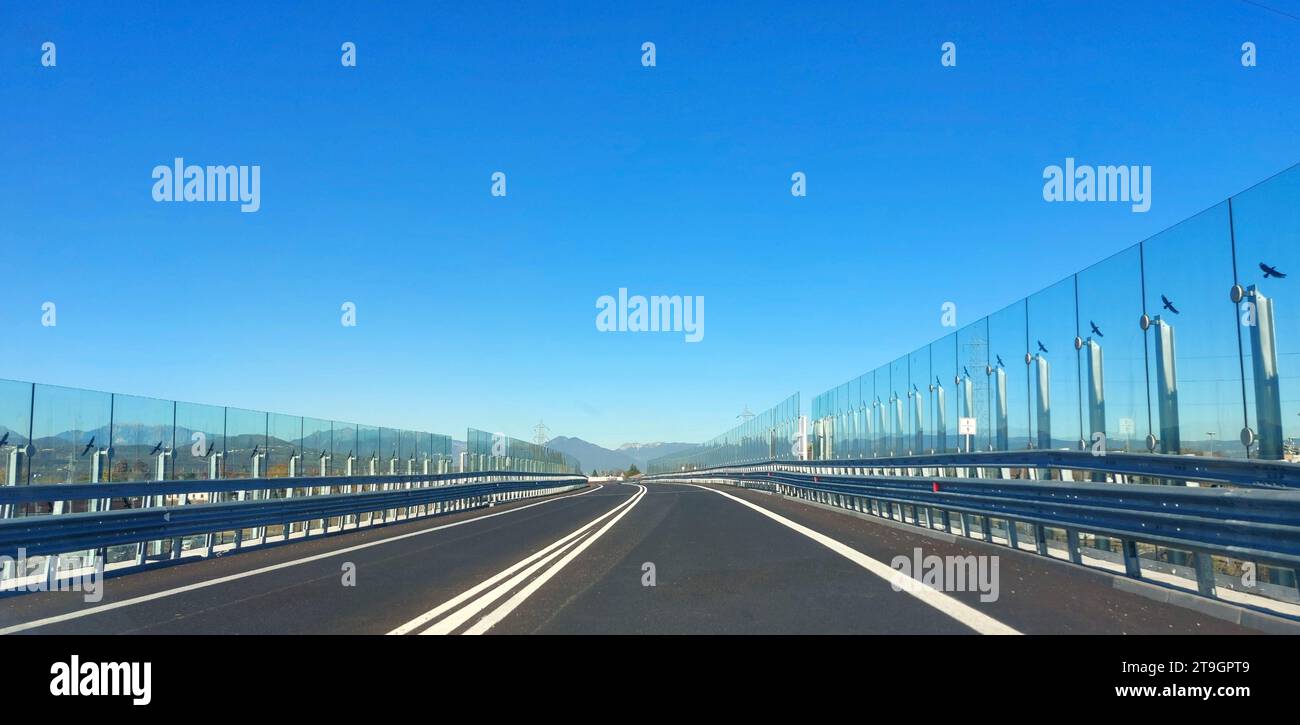 long sound-absorbing noise barrier of transparent glass on the highway ...