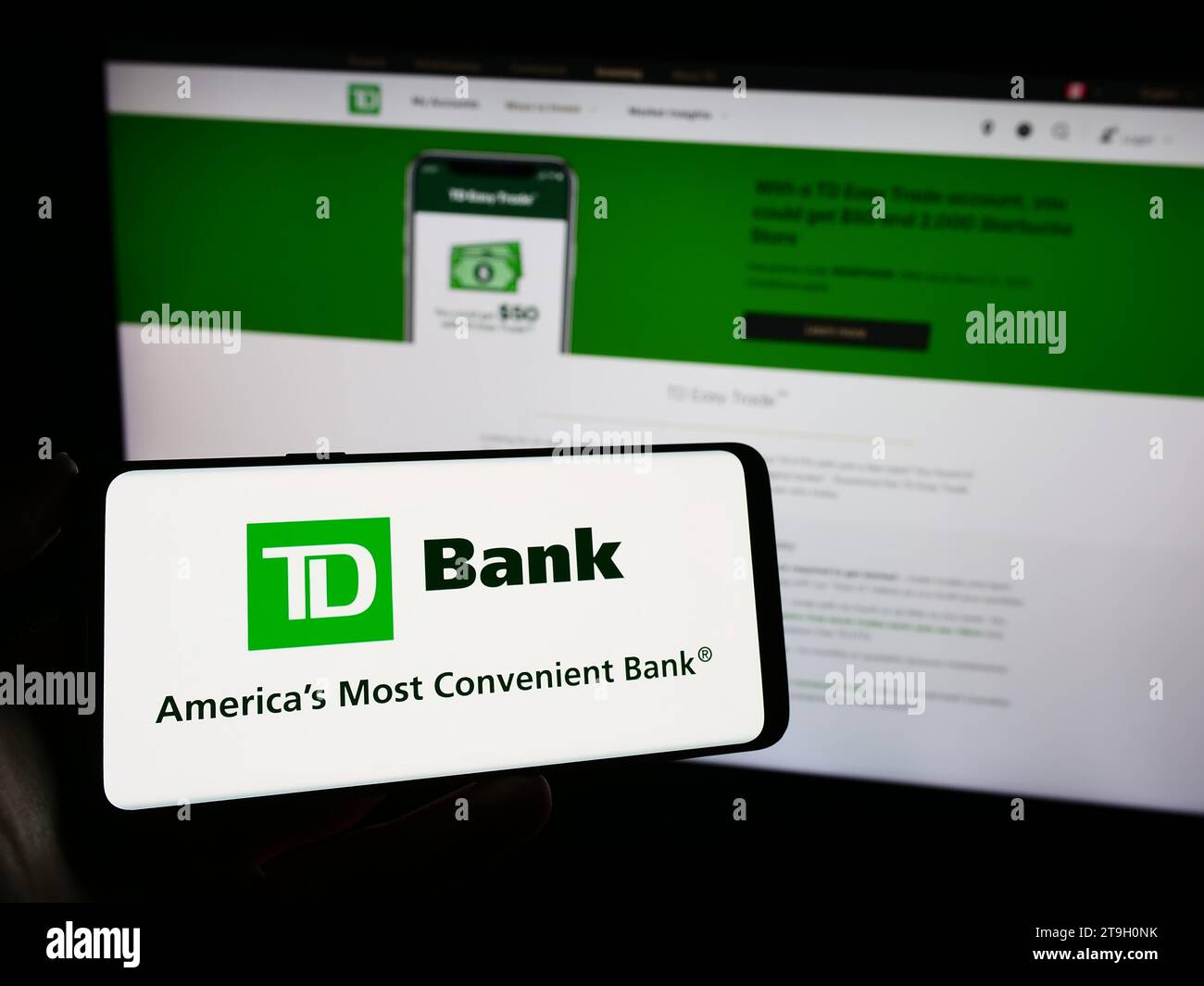 Person holding mobile phone with logo of financial services company ...