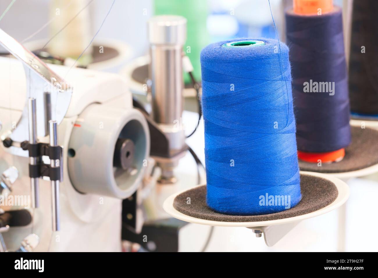 Spool of thread on an industrial sewing machine in a garment factory ...