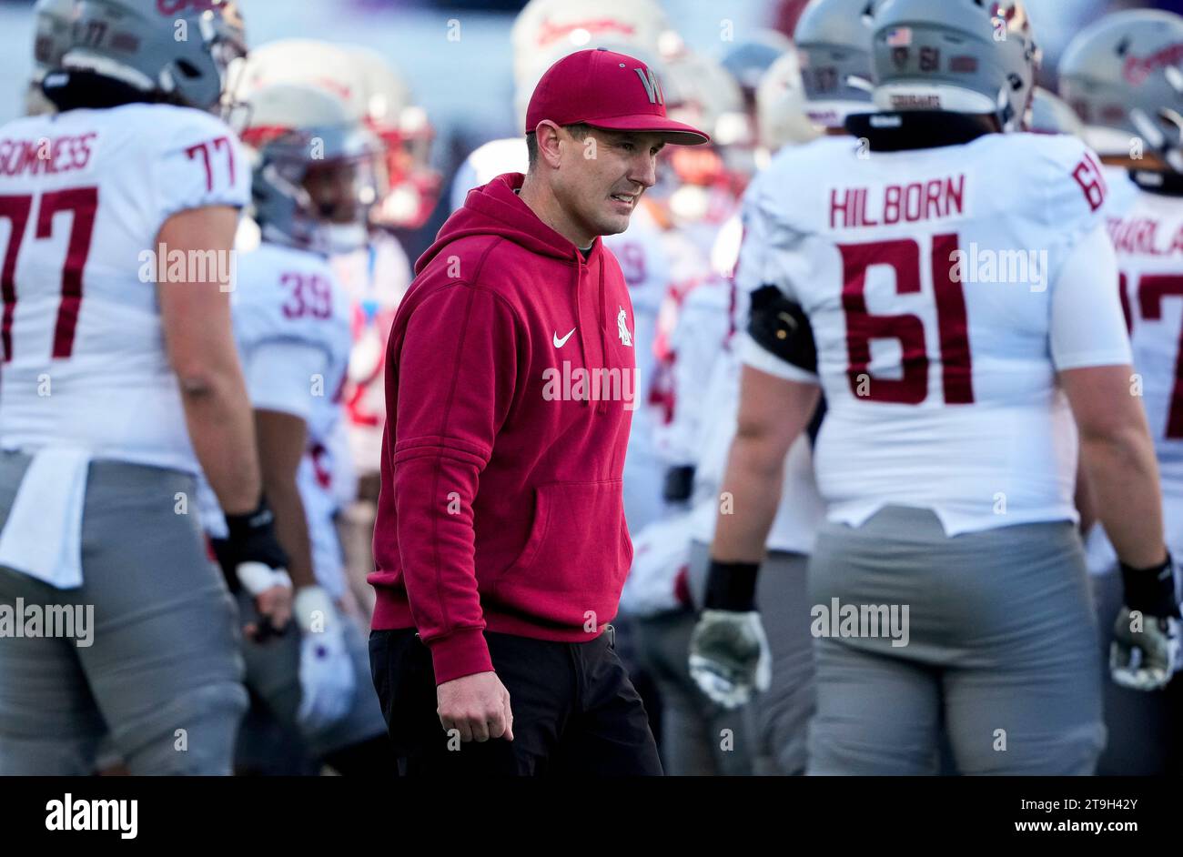 Washington State coach Jake Dickert walks on the field with players ...