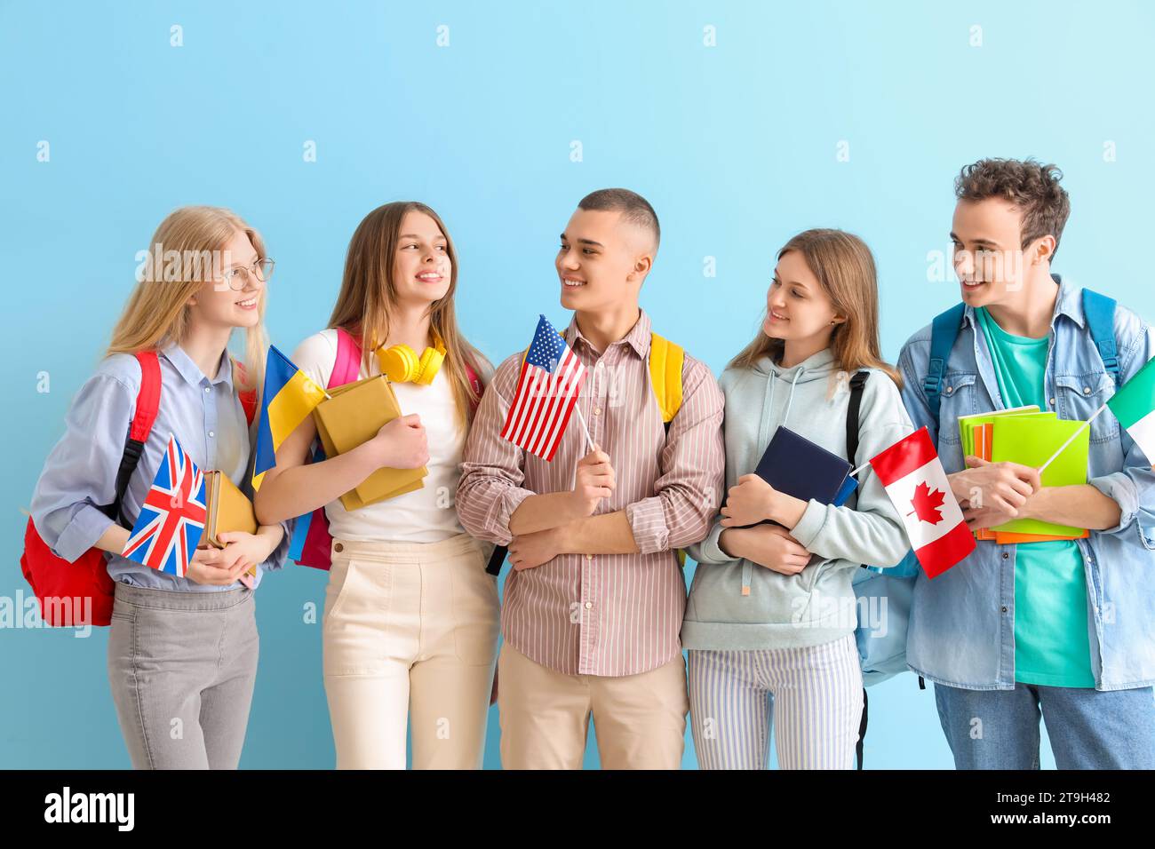 Group of students with books and flags of different countries on blue ...