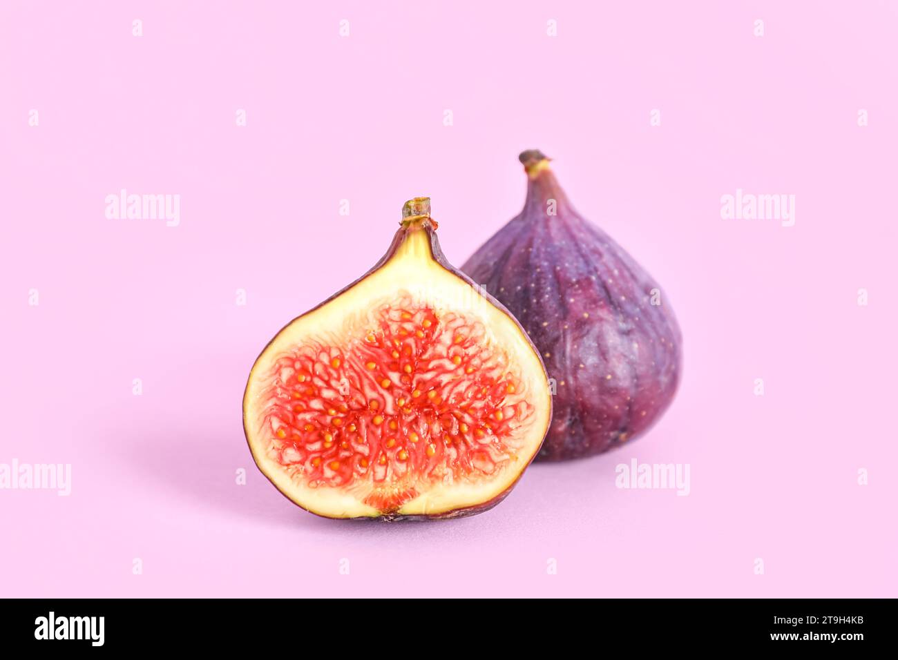 Fresh juicy cut figs on lilac background Stock Photo - Alamy