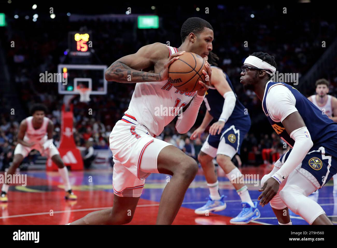 Houston Rockets forward Jabari Smith Jr., center, drives around Denver ...