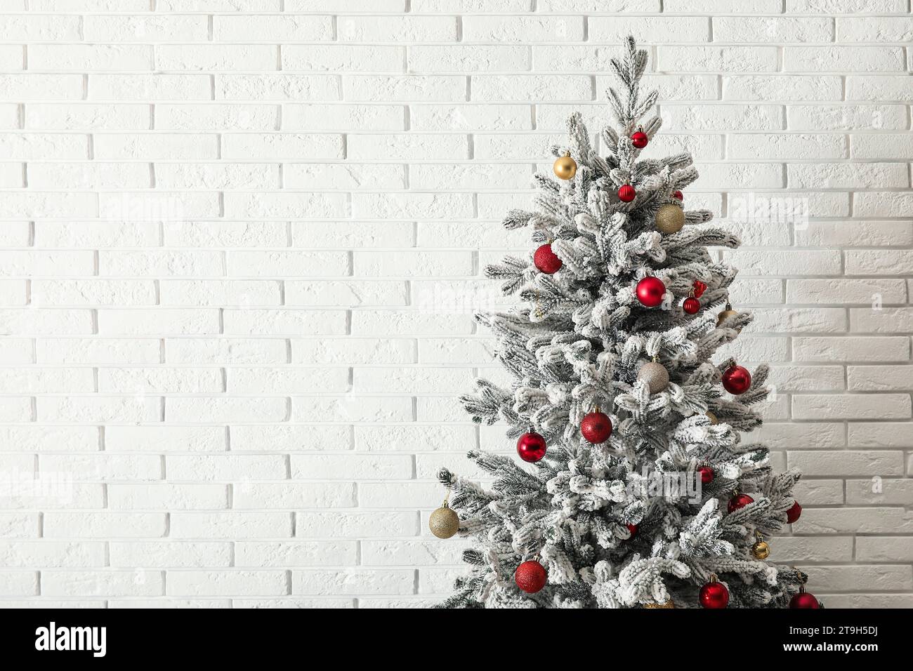 Beautiful Christmas tree on white brick background Stock Photo - Alamy