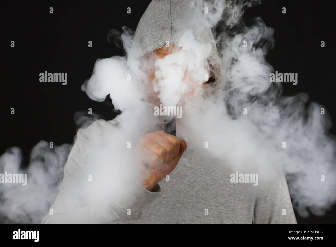 vaping man holding a mod cloud of vapor Black background isolated ...