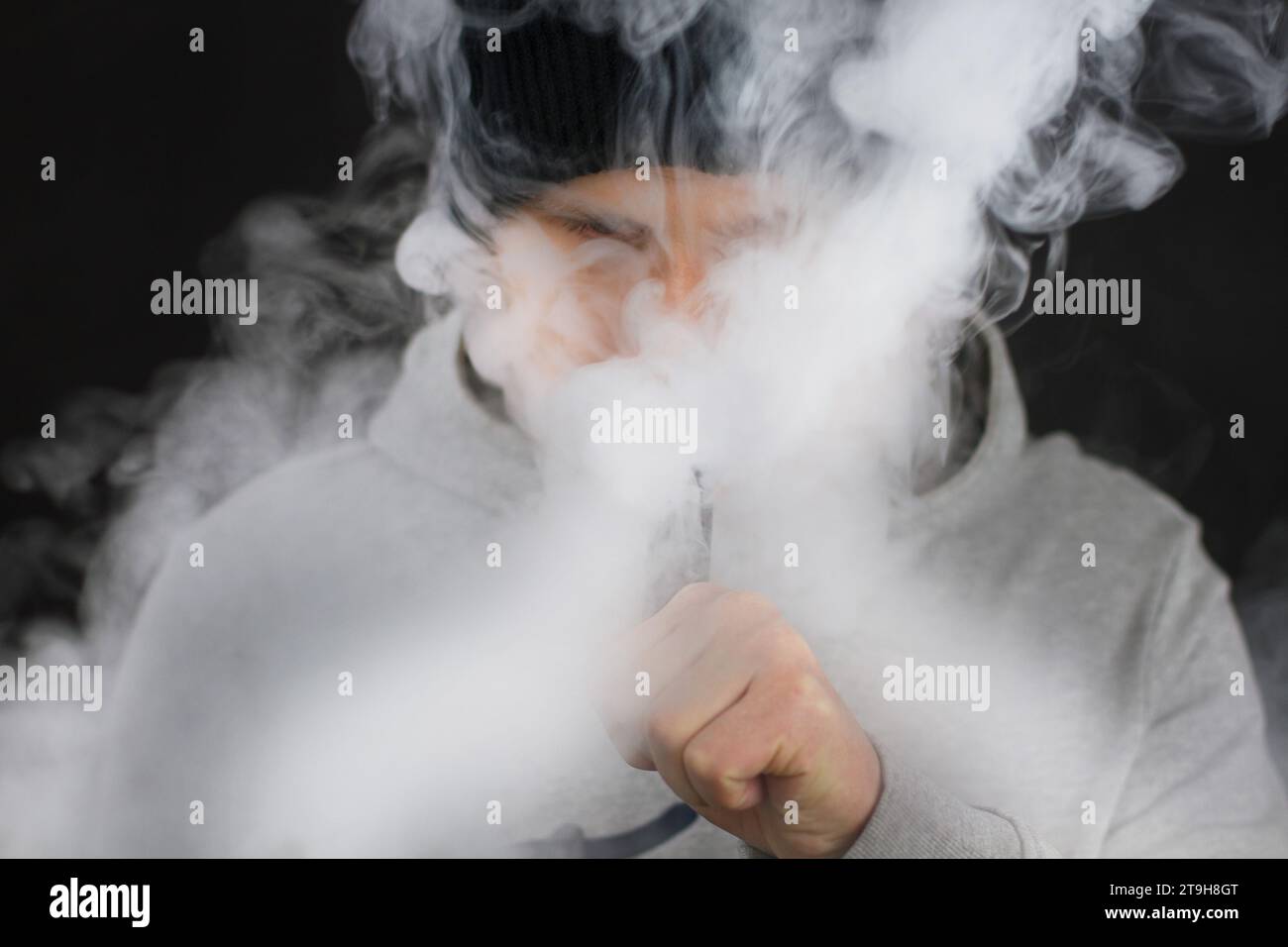 The man smoke an electronic cigarette on the dark background, Men in ...