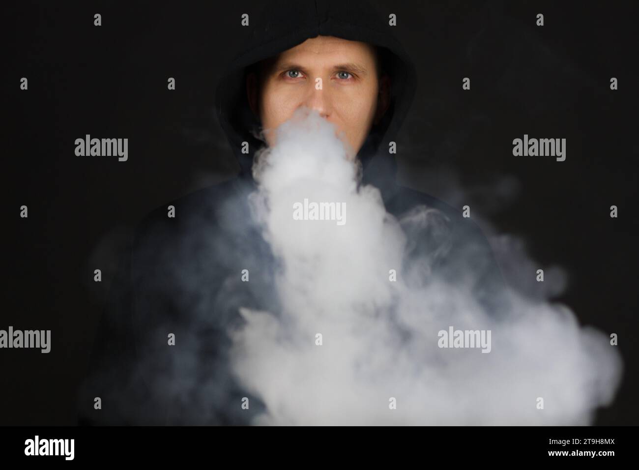 The man smoke an electronic cigarette on the dark background, Men in ...