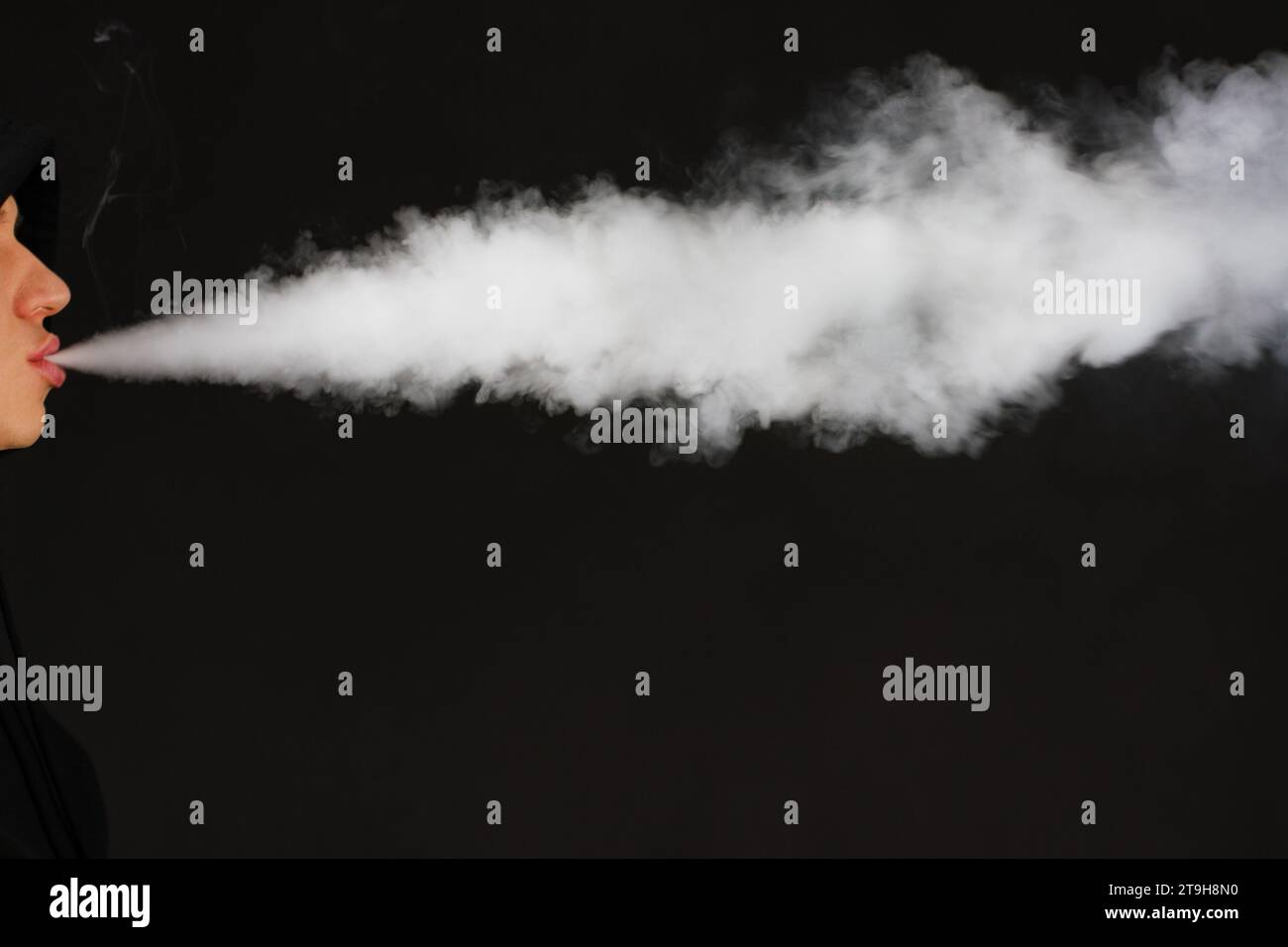 Vaping white man holding a mod. A cloud of vapor. Black background ...