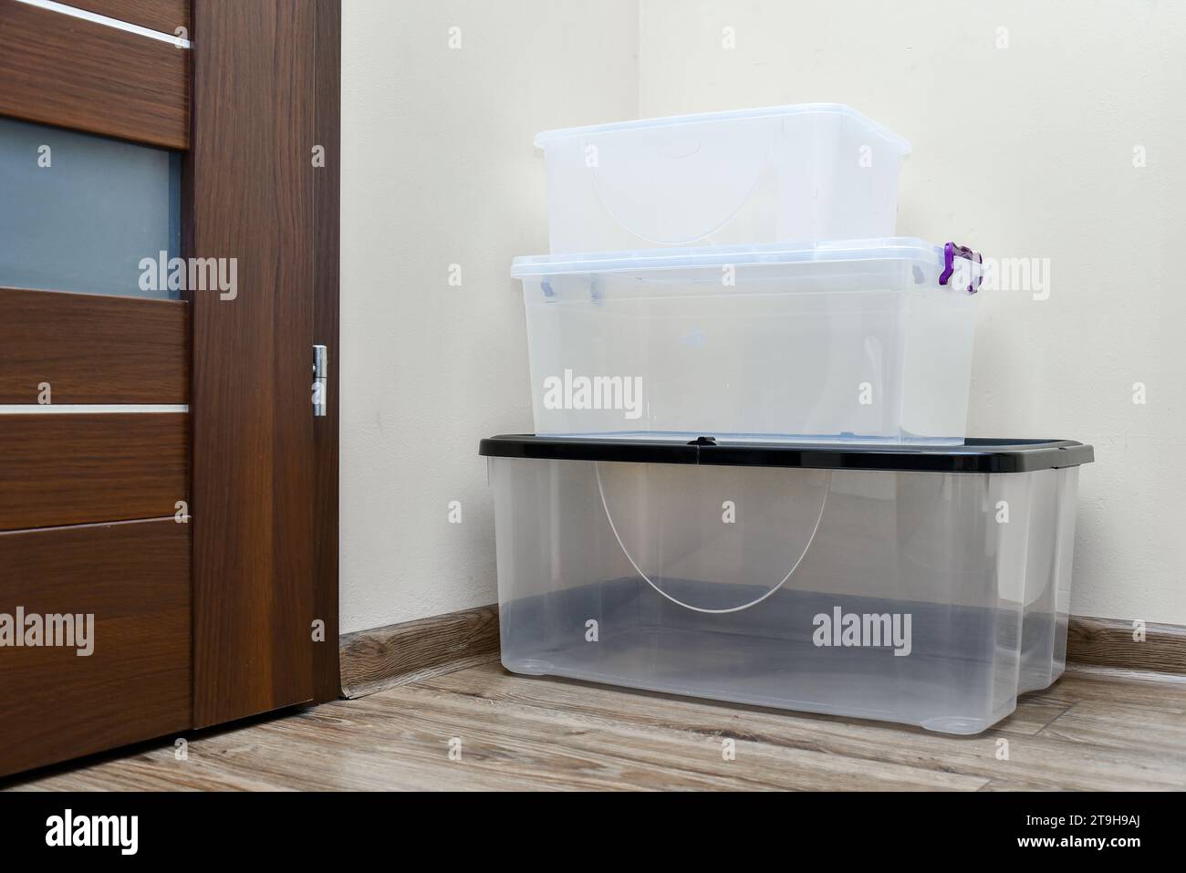 Empty plastic storage boxes stacked on the floor of the room. Boxes ...