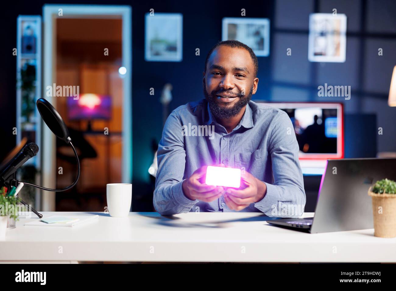 Smiling tech influencer filming brand sponsored mini RGB lights device ...