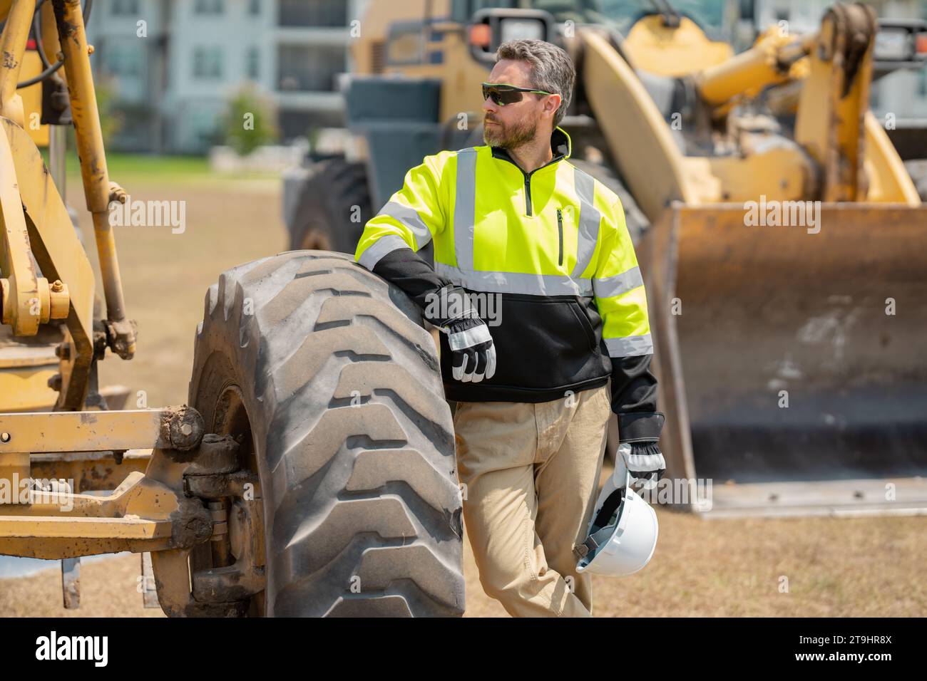 Portrait of builder in a construction site. Builder with excavator ...