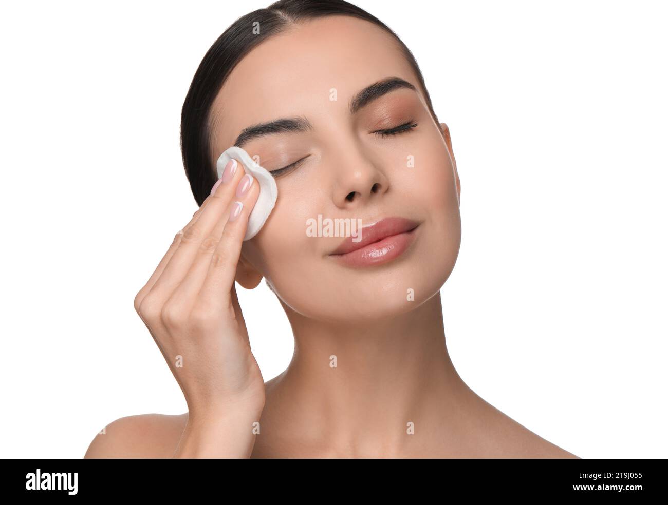 Beautiful woman removing makeup with cotton pad on white background ...