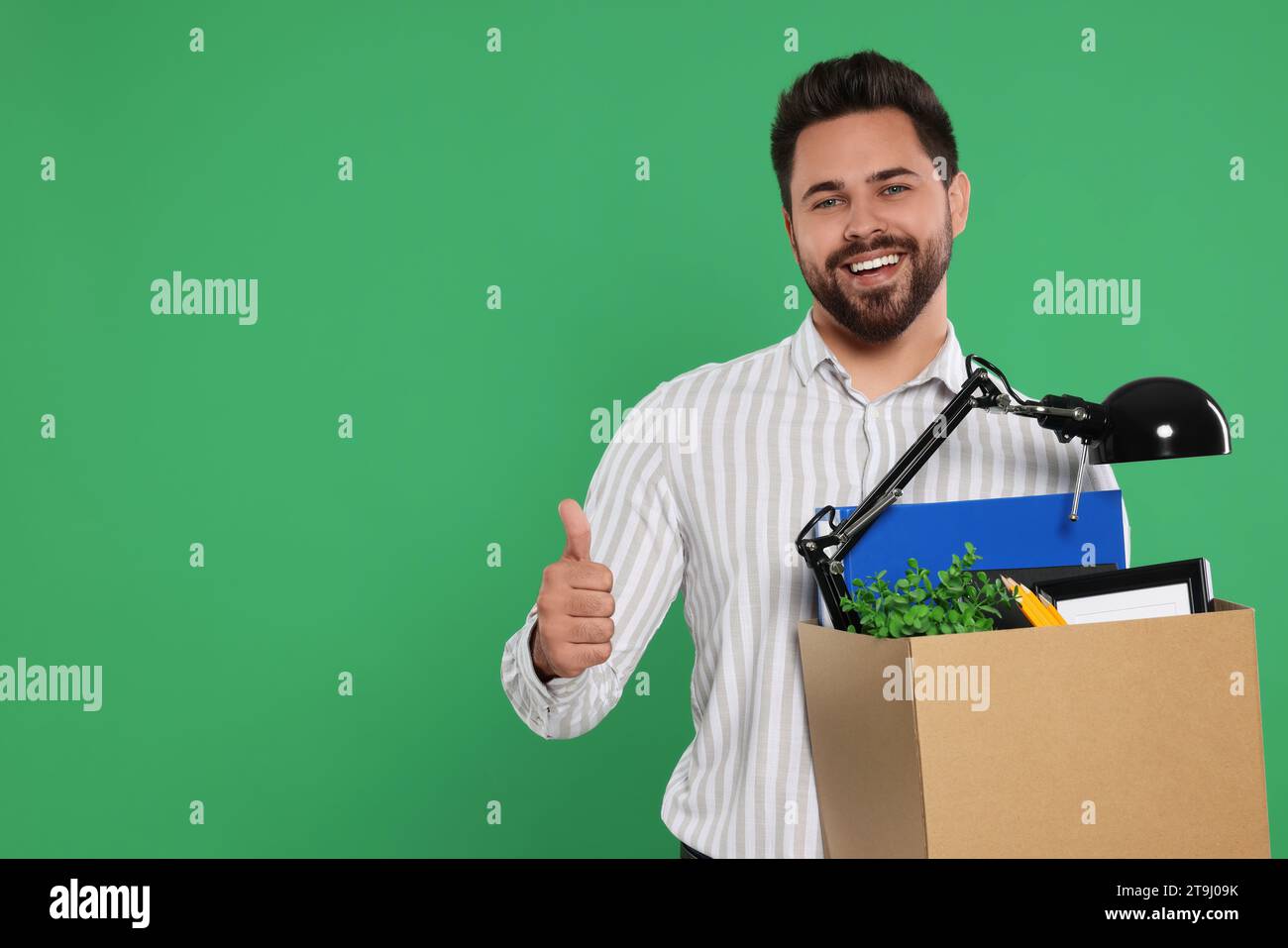 Happy unemployed man with box of personal office belongings showing ...