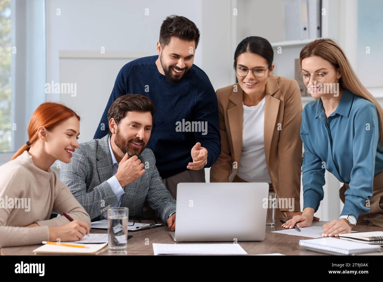 Team of employees working together in office Stock Photo - Alamy
