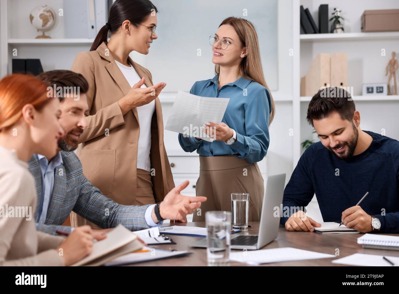 Team of employees working together in office Stock Photo - Alamy