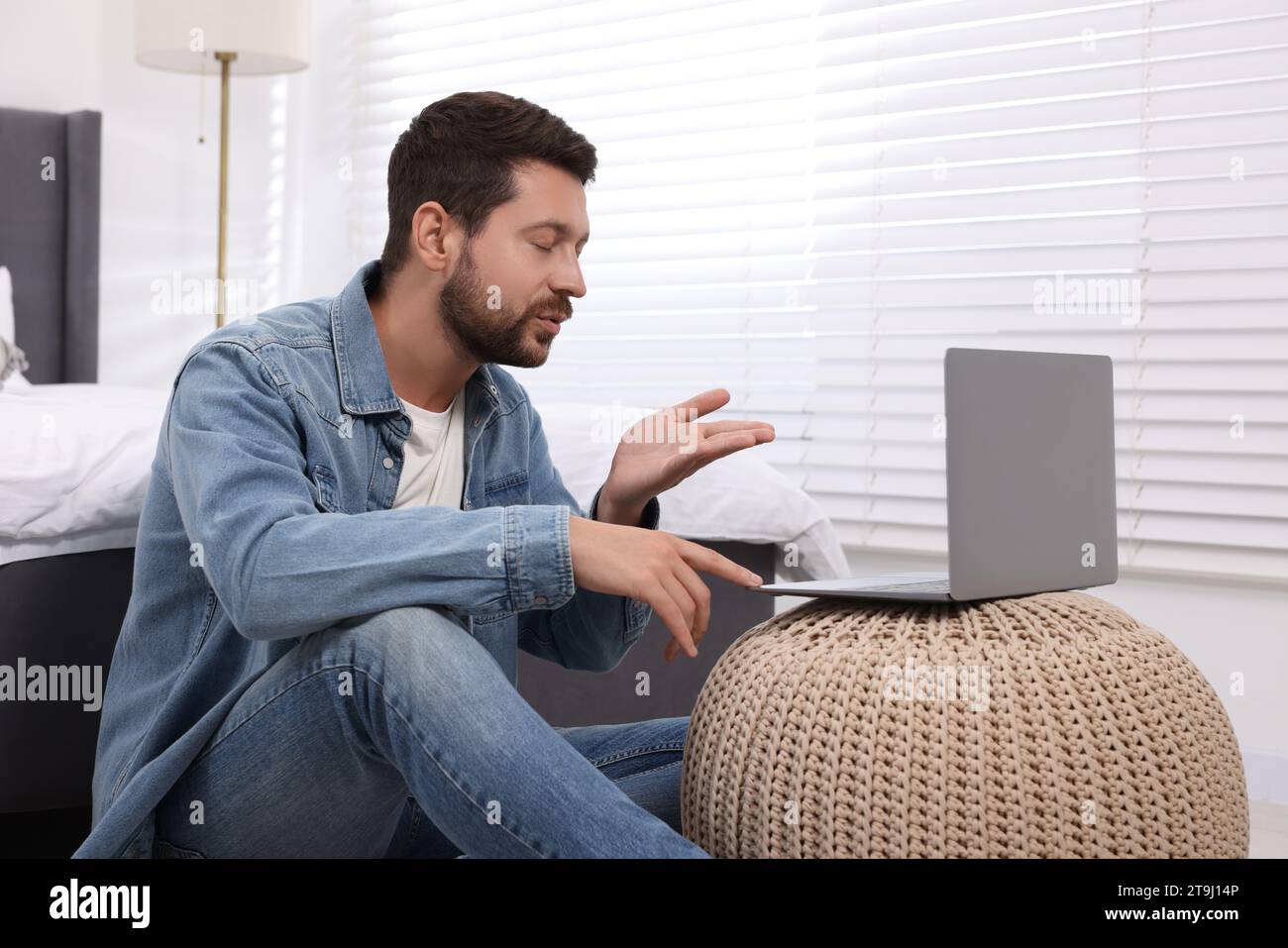 Man blowing kiss during video chat via laptop at home. Long-distance ...